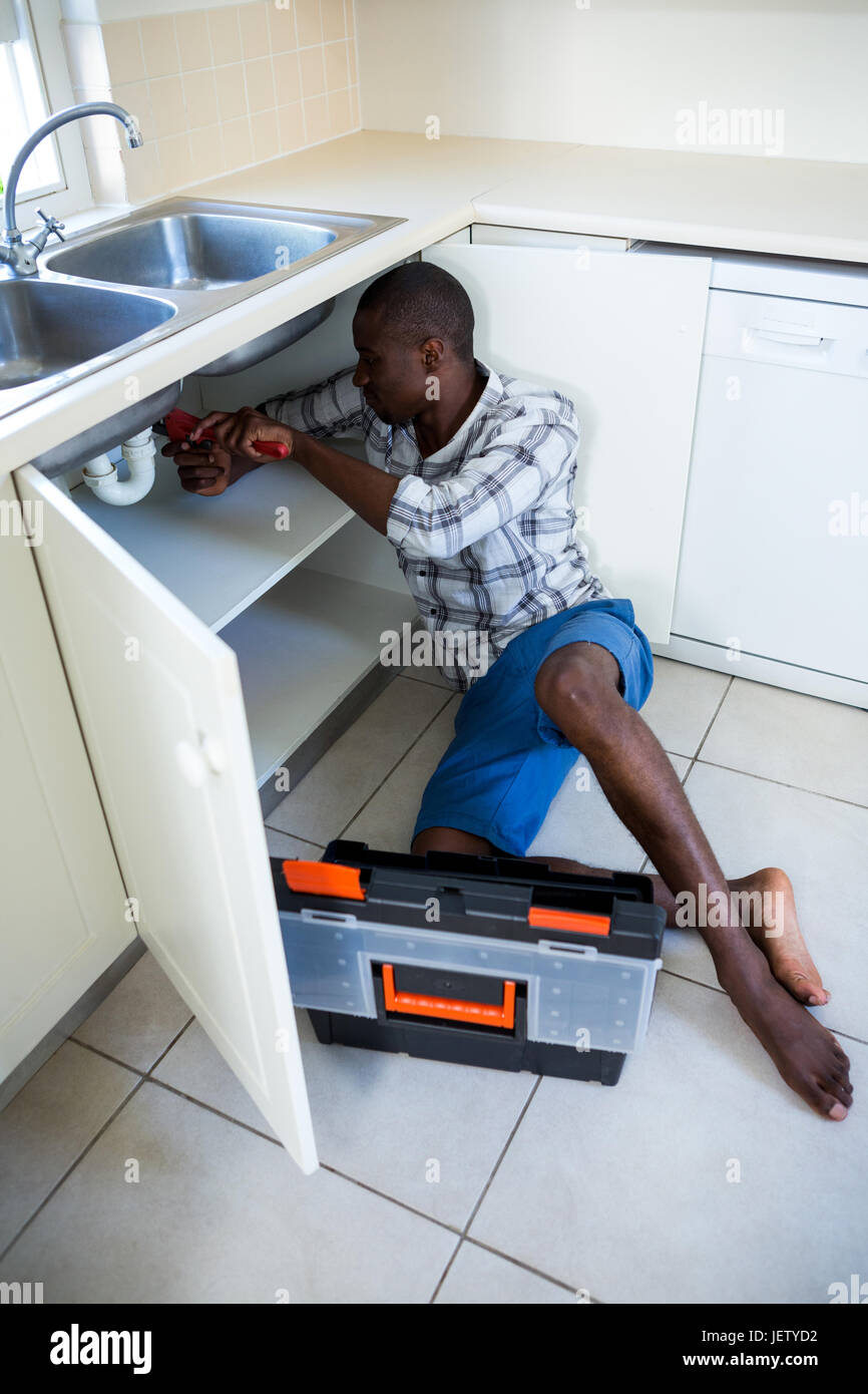 Man repairing a kitchen sink Stock Photo - Alamy