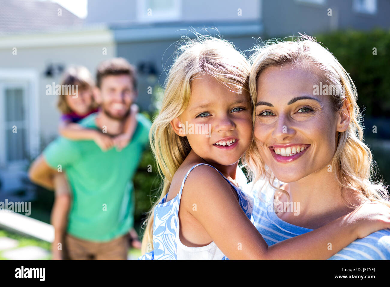 Smiling parents carrying children Stock Photo - Alamy