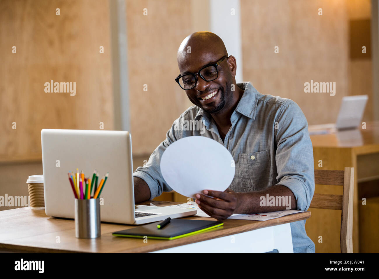 Graphic designer using laptop in office Stock Photo - Alamy
