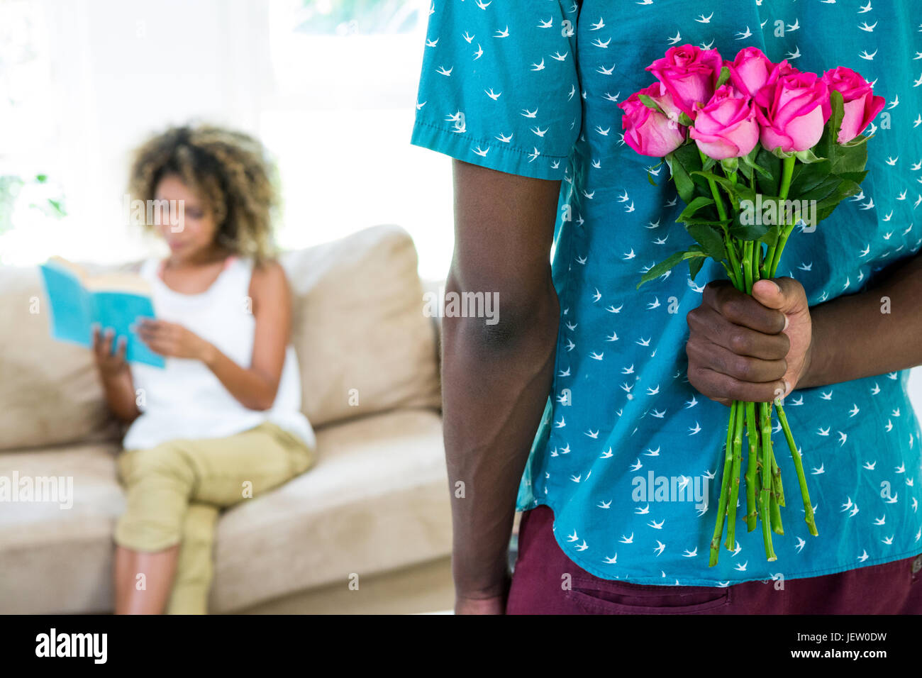 Man hiding flower from the woman Stock Photo - Alamy