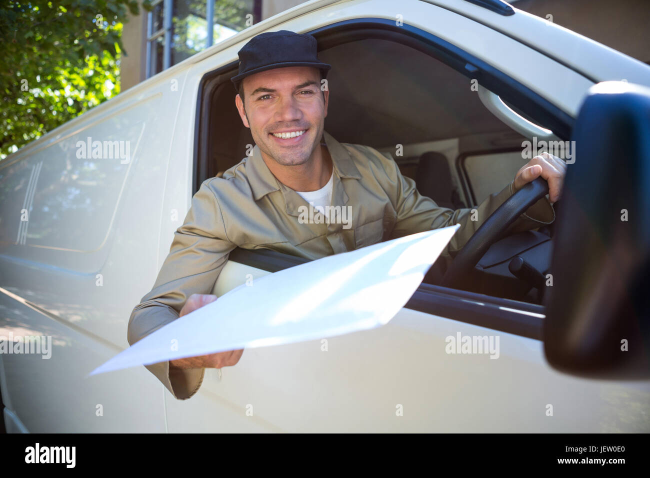 Smiling delivery man sitting in his van Stock Photo - Alamy