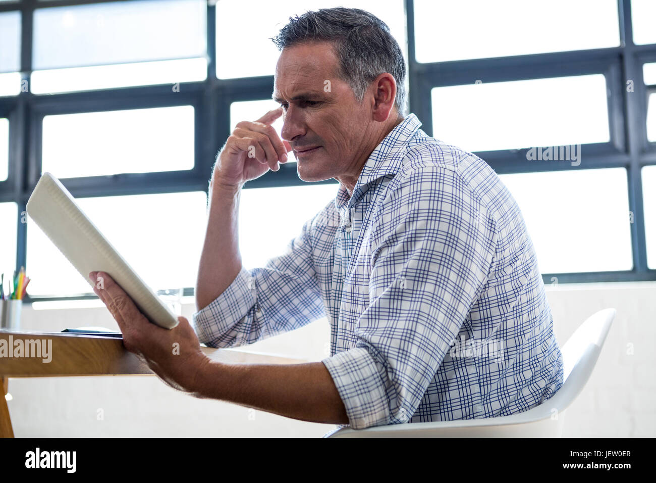 Thoughtful male executive using digital hi-res stock photography and ...