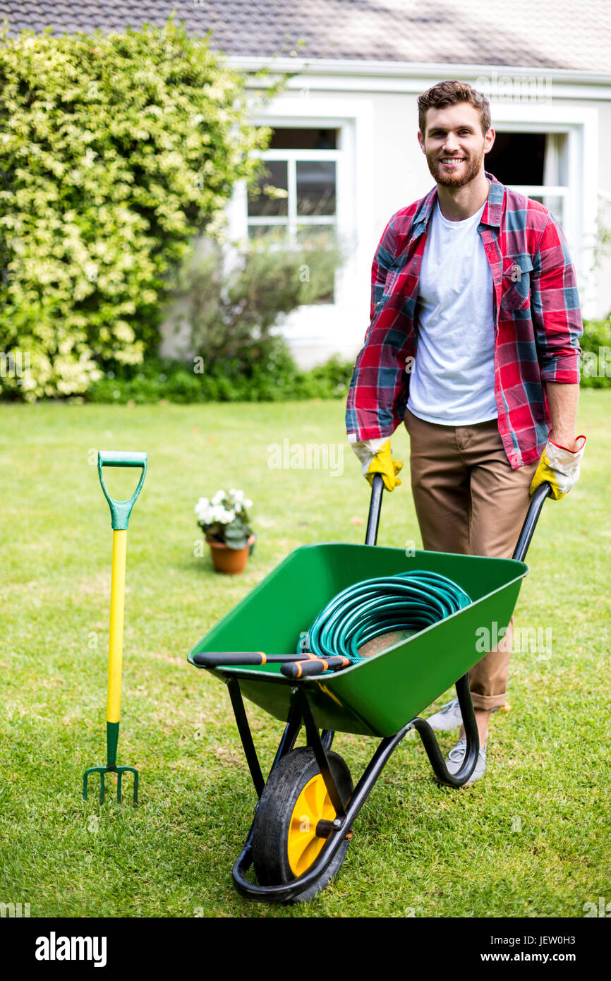 Man holding rake in yard Stock Photo - Alamy
