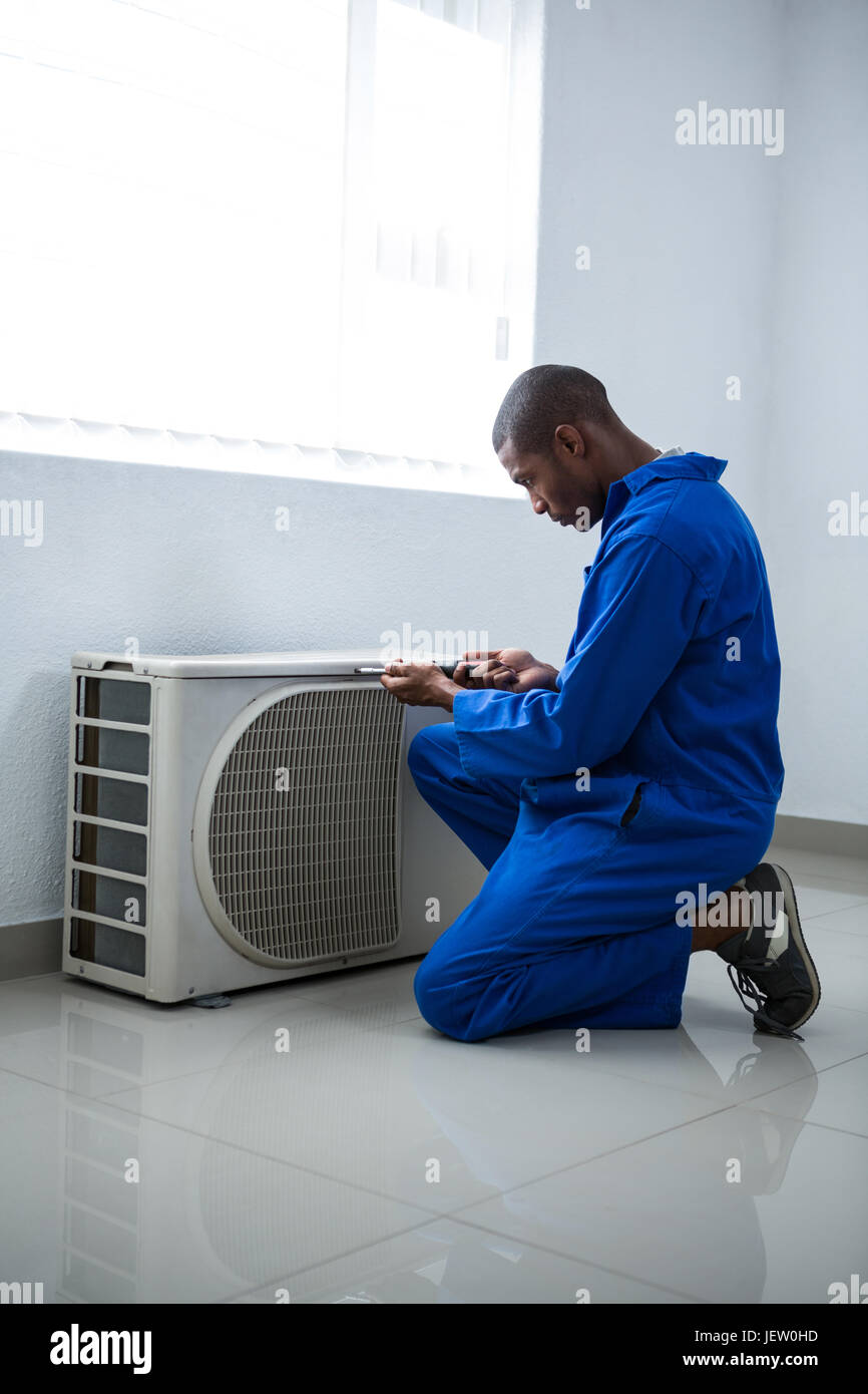 Handyman testing air conditioner Stock Photo - Alamy
