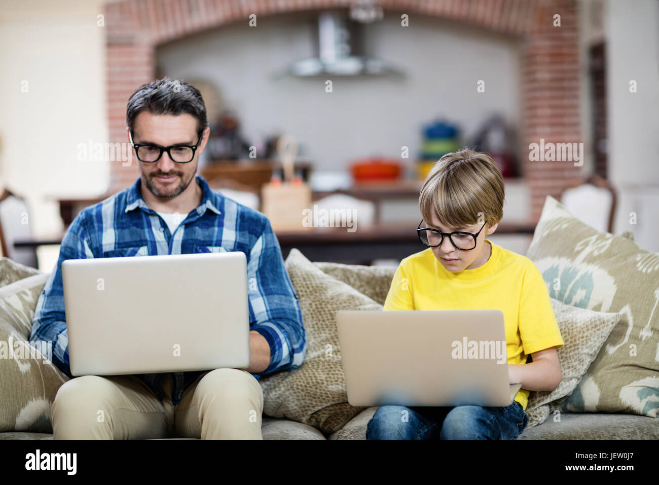 Father and son using laptop in living room Stock Photo - Alamy