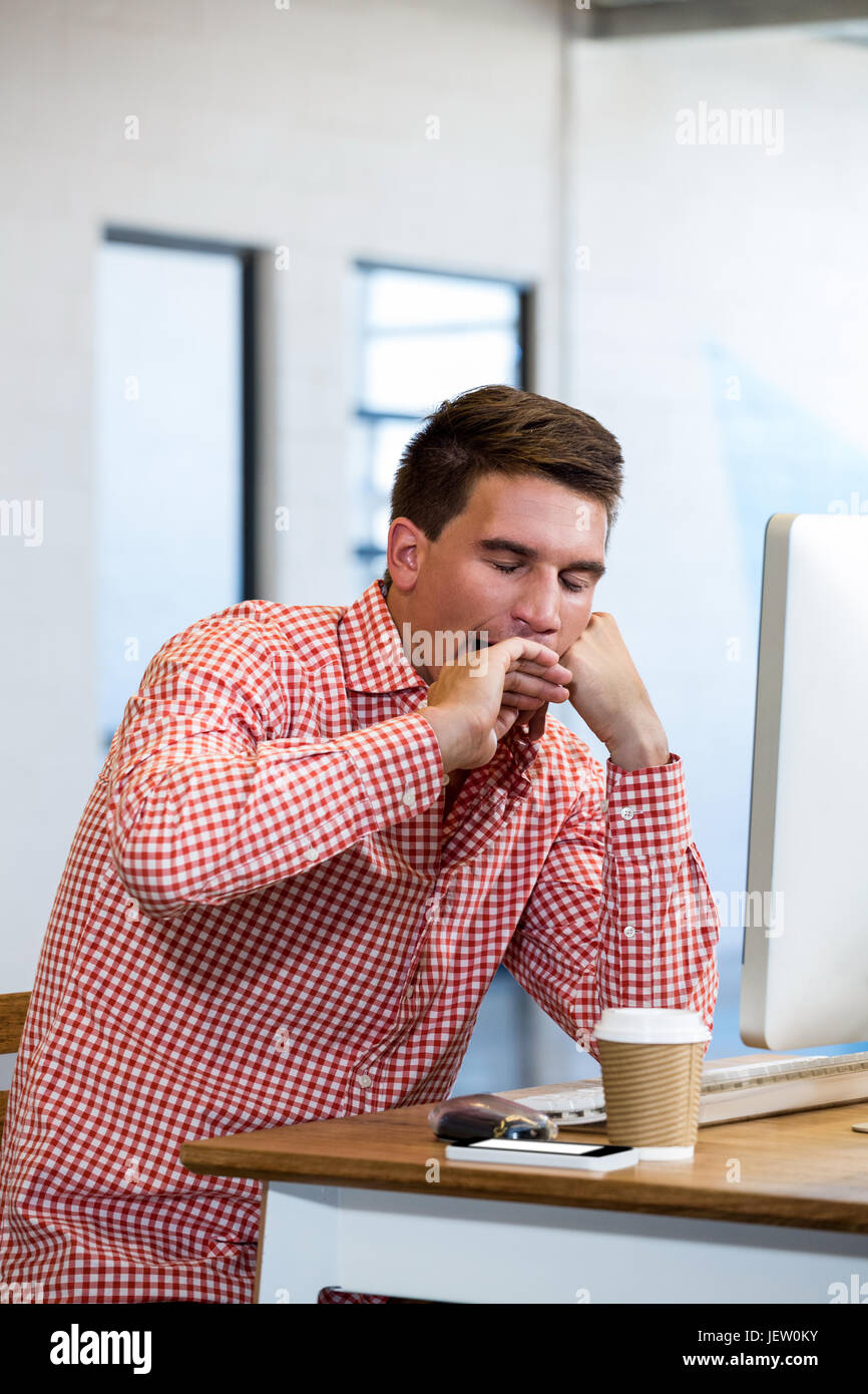 Man yawning at his desk Stock Photo - Alamy