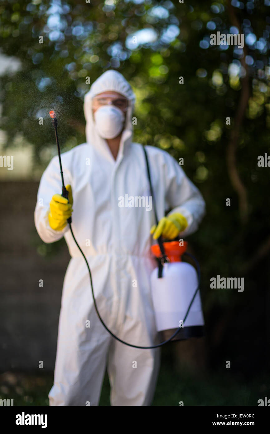 Front view of worker spraying chemical Stock Photo - Alamy