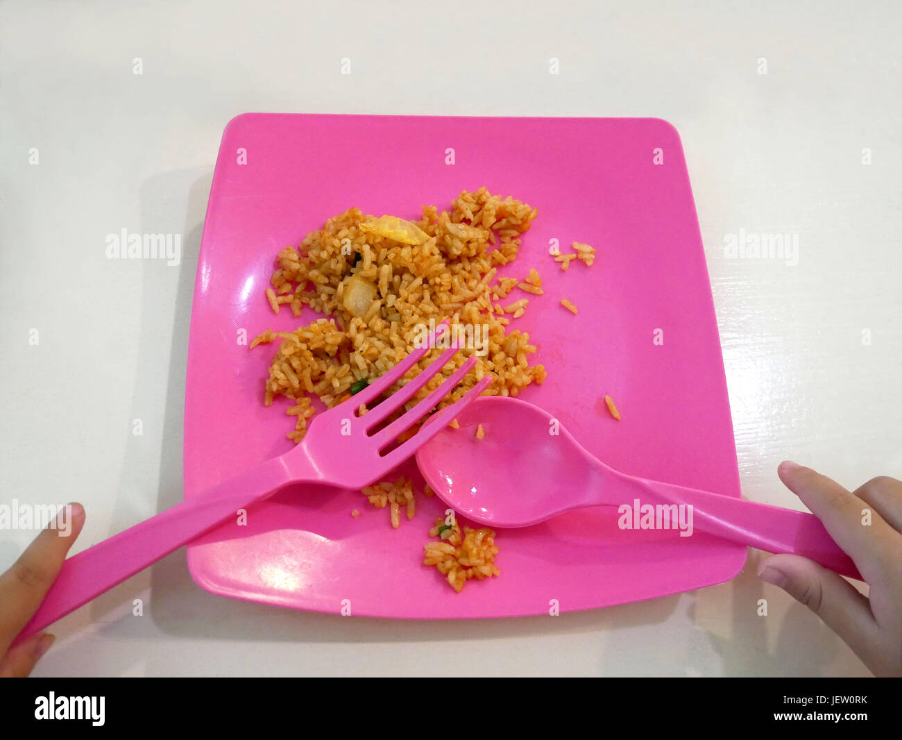Little child use spoon and fork to eat fried rice Stock Photo - Alamy