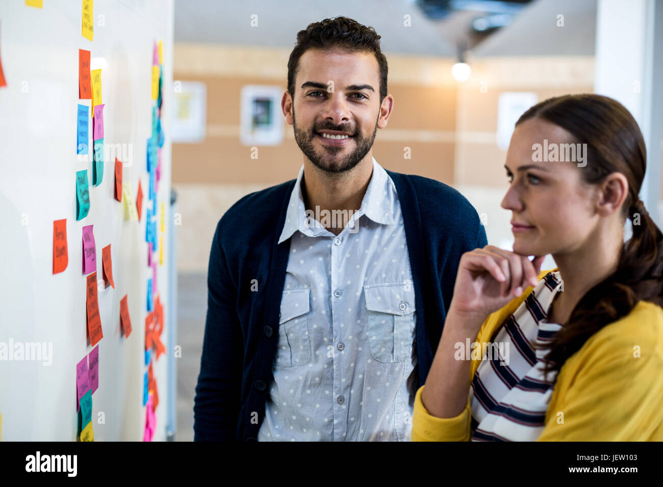 Colleagues looking at white board Stock Photo - Alamy