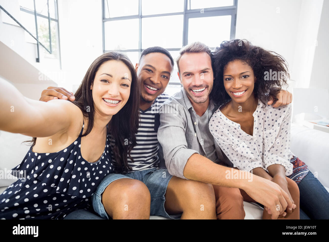 Friends sitting together on sofa Stock Photo - Alamy