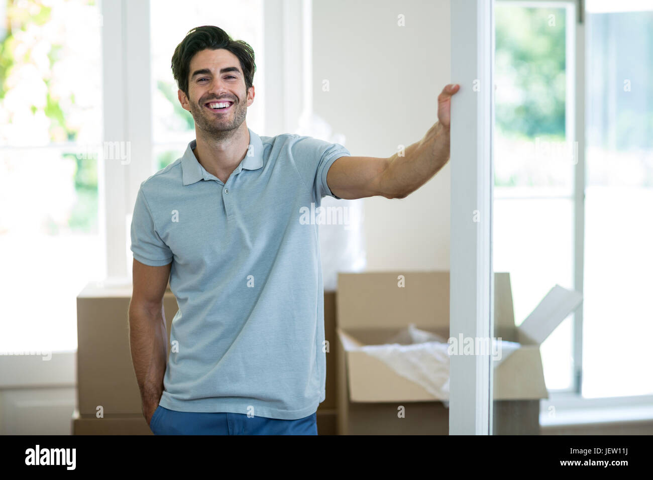 Young man standing in his new house Stock Photo - Alamy