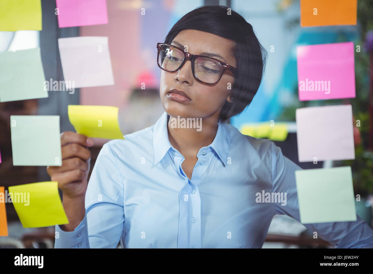 Businesswoman looking at sticky note Stock Photo - Alamy