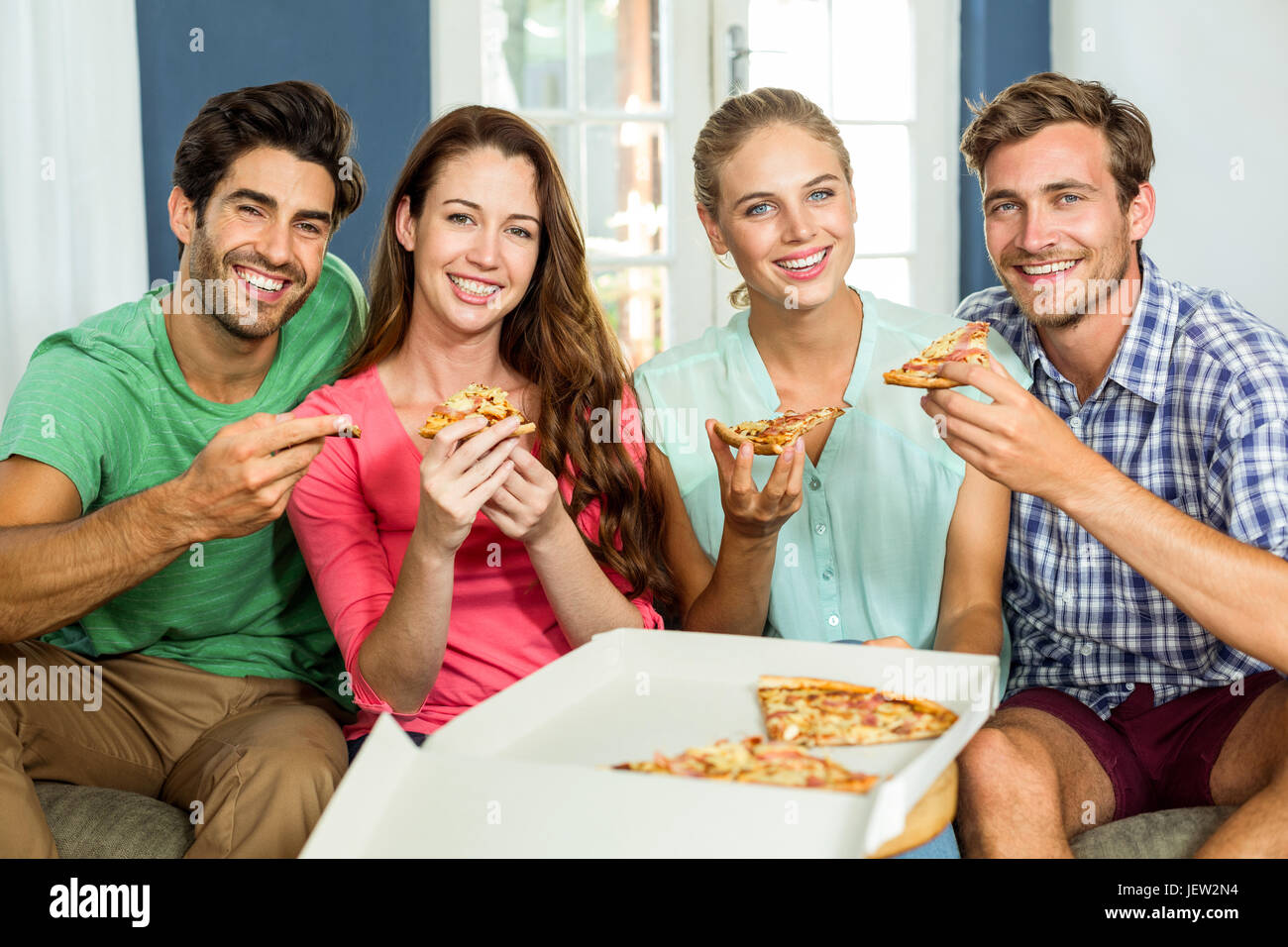 Portrait of happy friends eating pizza Stock Photo - Alamy