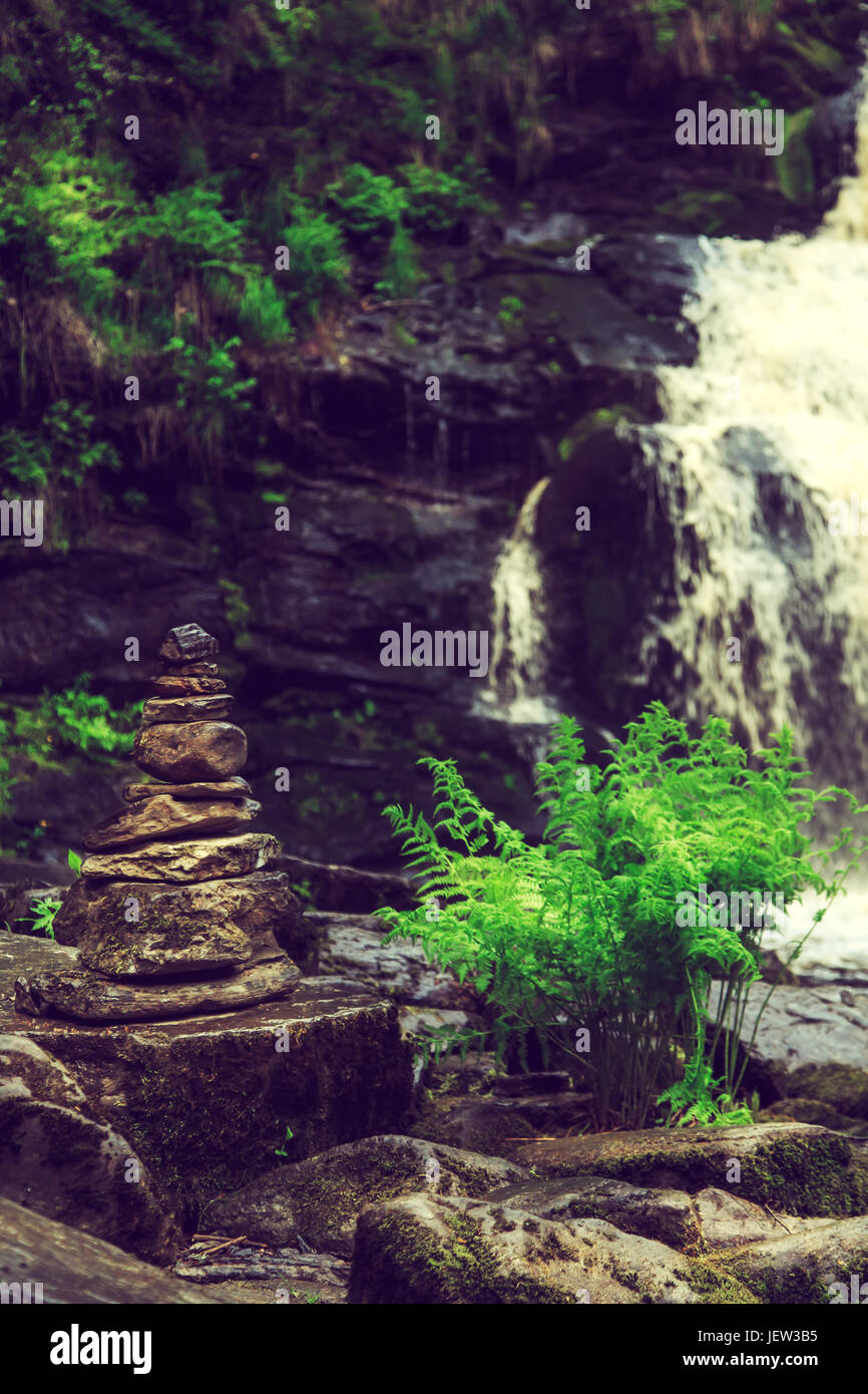 Stone pyramid near a tropical waterfall. The concept of harmony and ...