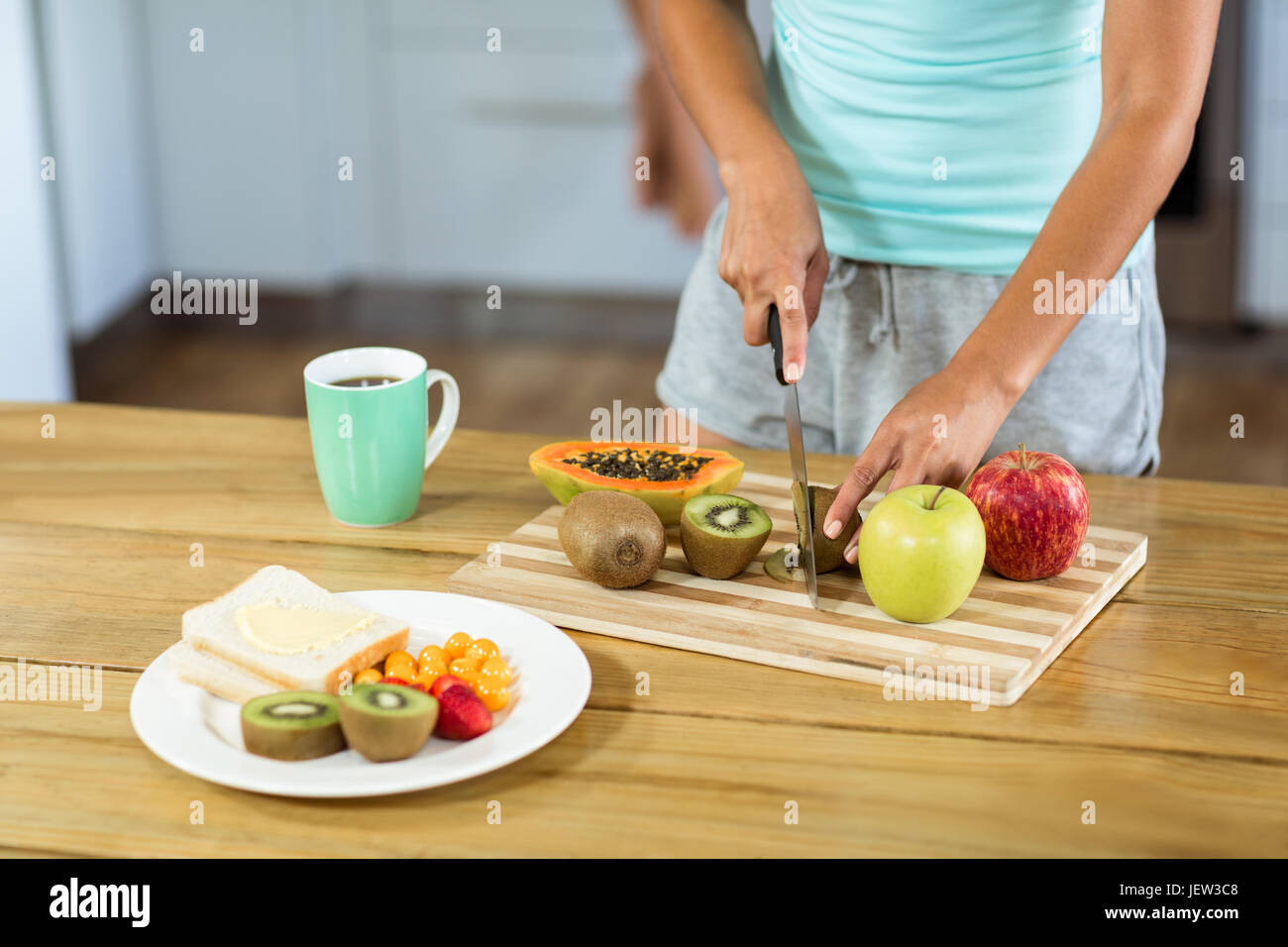 Woman cutting fruits at kitchen counter Stock Photo - Alamy