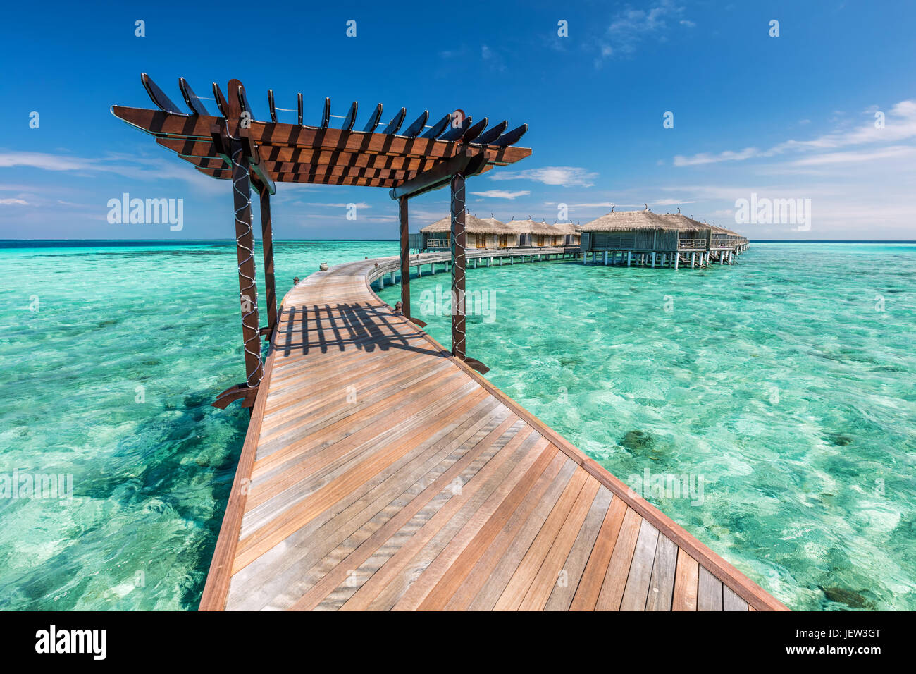 Wooden jetty towards water villas in Maldives. Resort on an island on ...