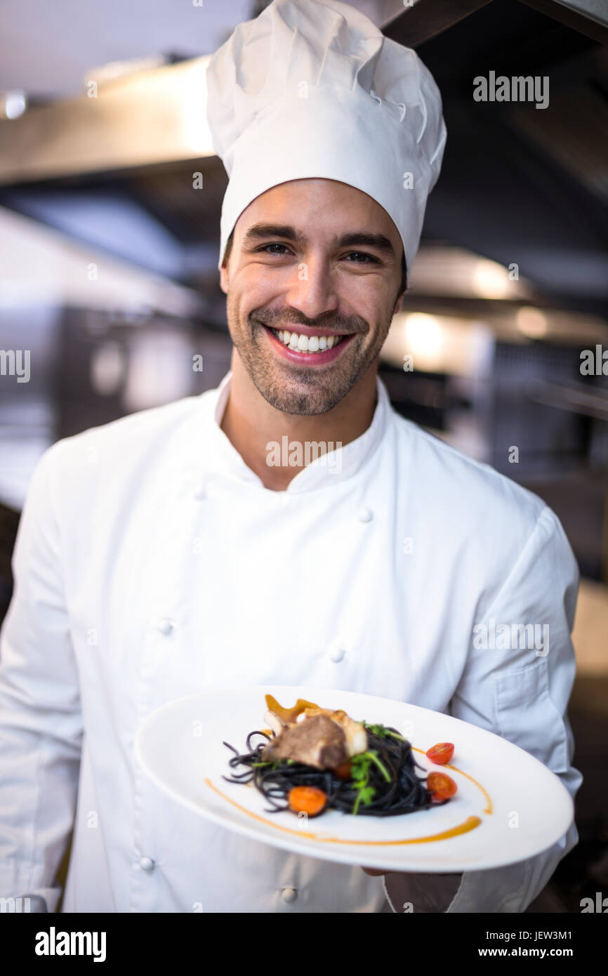 Handsome chef presenting meal Stock Photo - Alamy