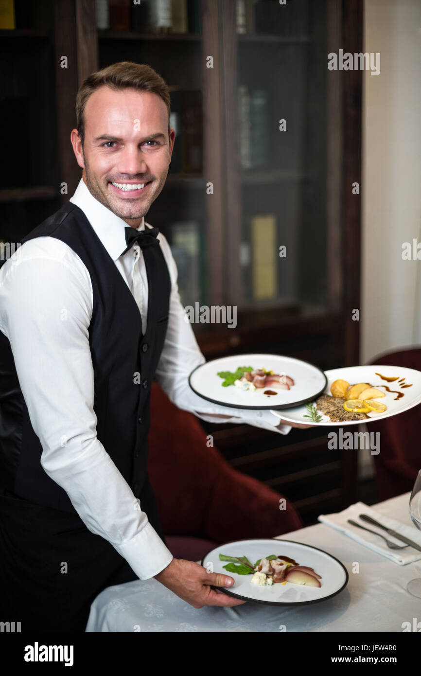Handsome waiter serving meal Stock Photo - Alamy