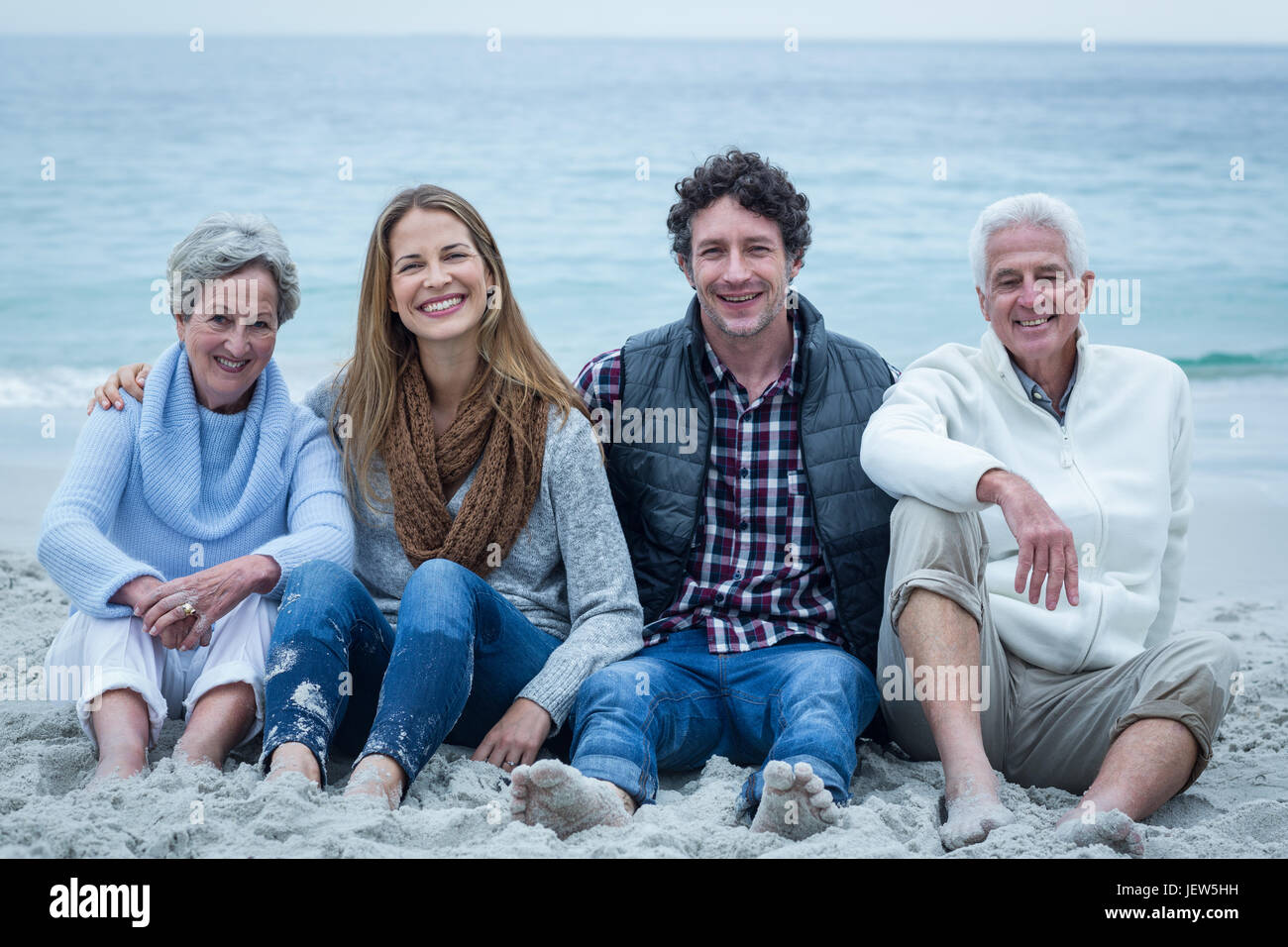 Family sitting at sea shore Stock Photo - Alamy