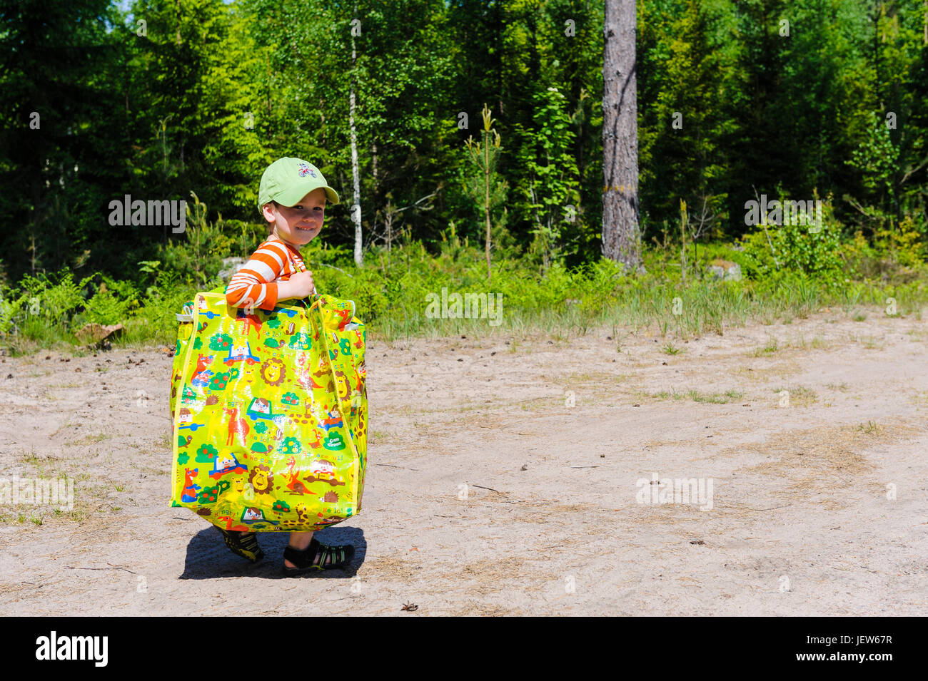 Smiling boy carrying big bag Stock Photo - Alamy