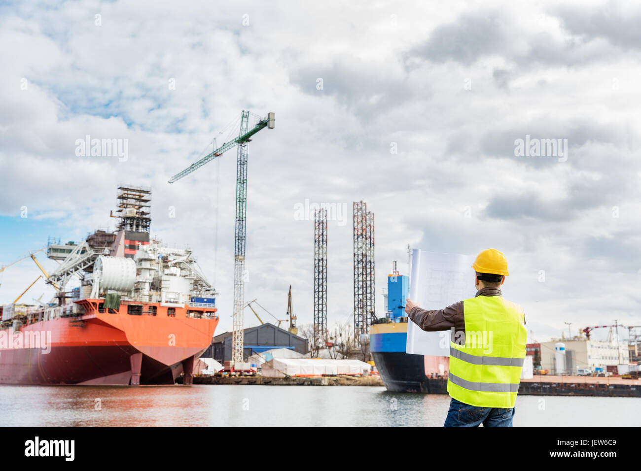 Shipbuilding engineer checking documents and plans of construction at ...