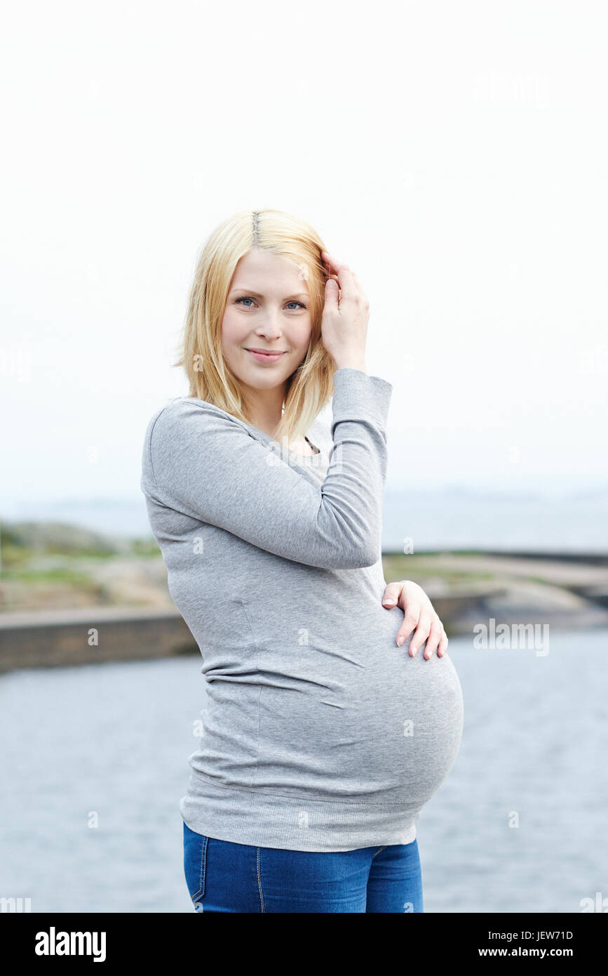 Pregnant woman with hands on hell belly Stock Photo - Alamy