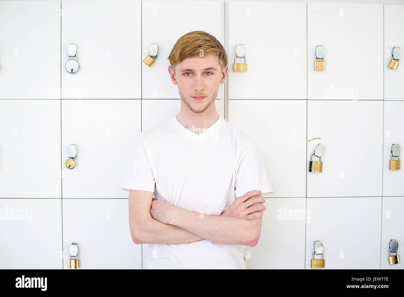 Portrait of young man with lockers on background Stock Photo - Alamy