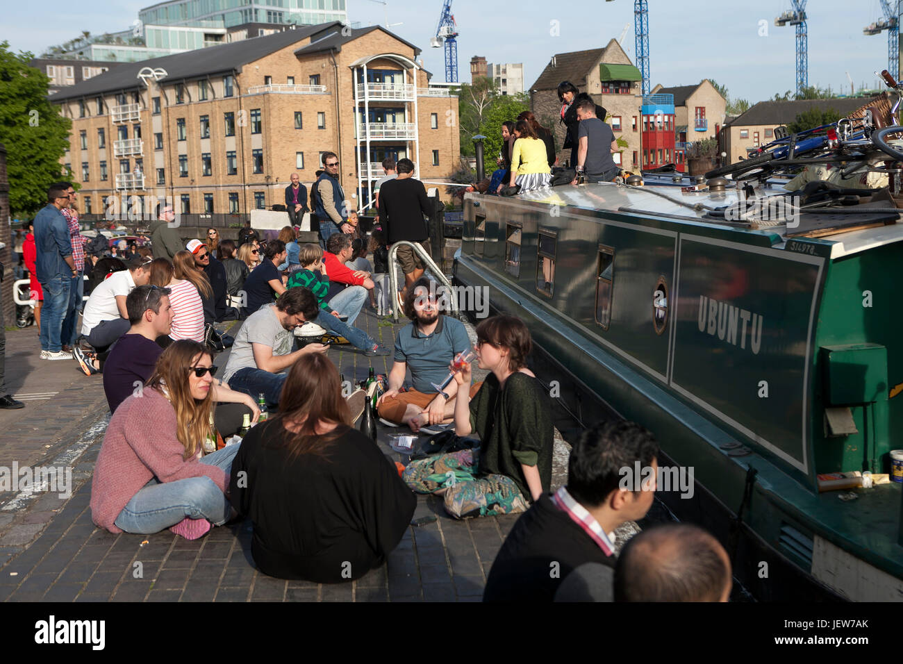 LONDON, ENGLAND - JULY 12, 2017 Unknown young local people sitting ...