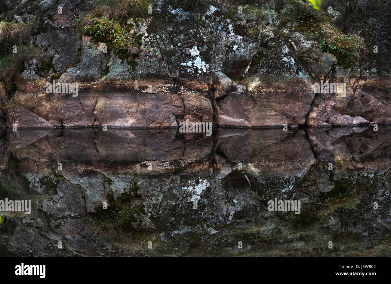 Rocks reflecting in water Stock Photo - Alamy