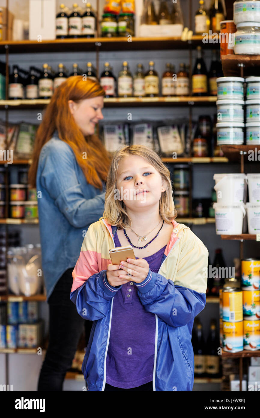 Girl with cell phone in shop Stock Photo - Alamy
