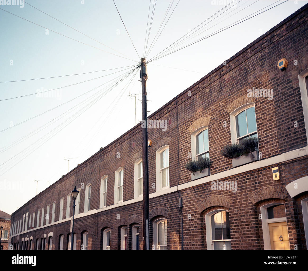 Electricity pole in front of brick building Stock Photo - Alamy