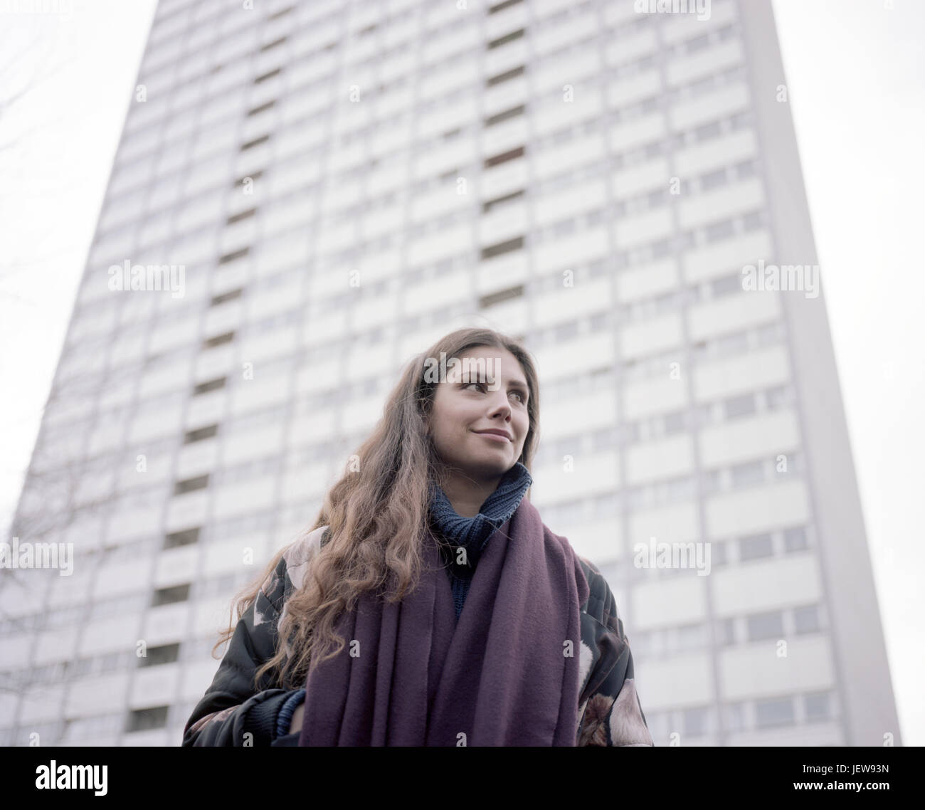 Young woman, tall building on background Stock Photo - Alamy
