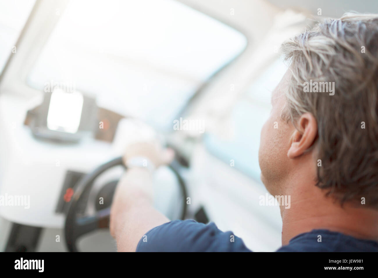 Man steering boat Stock Photo - Alamy