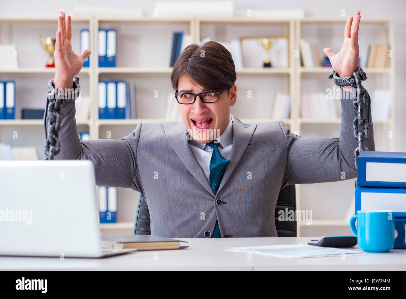 Businessman tied with chains to his work Stock Photo - Alamy