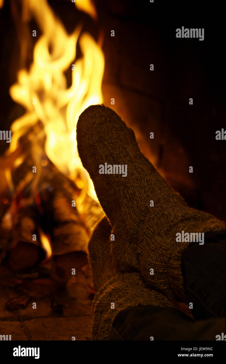 Feet in socks, fire on background Stock Photo - Alamy