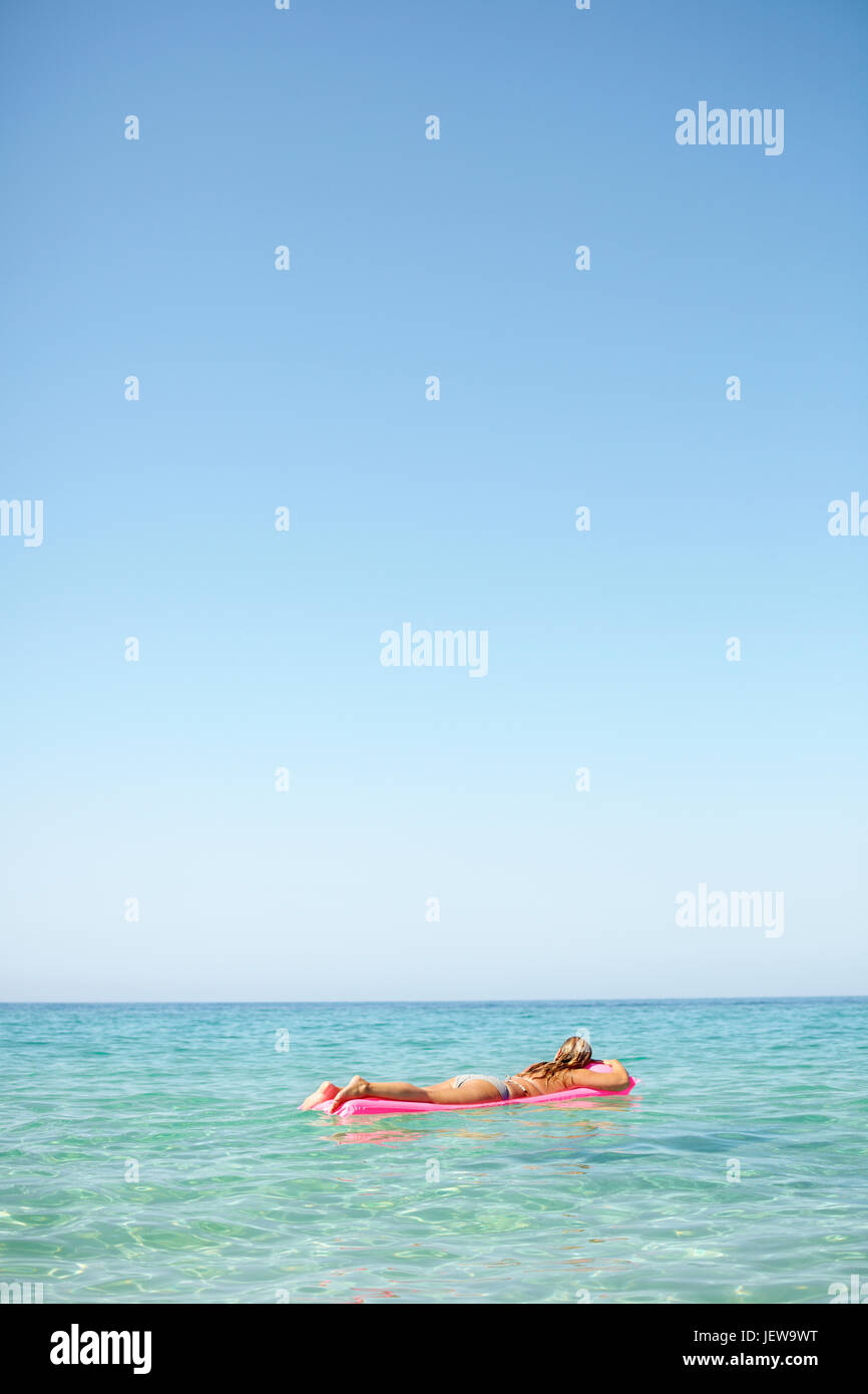Woman floating in inflatable mattress Stock Photo - Alamy