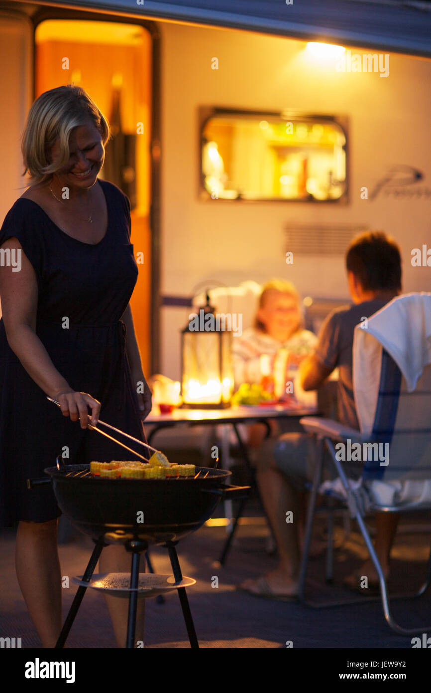 Family having barbecue at night Stock Photo - Alamy
