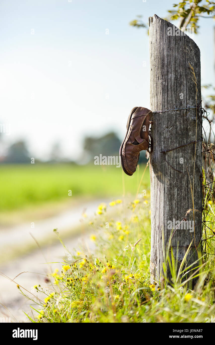Shoe hanging on wooden pole Stock Photo - Alamy