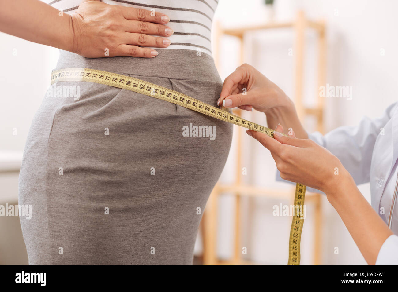 Nice woman measuring belly of her client Stock Photo - Alamy