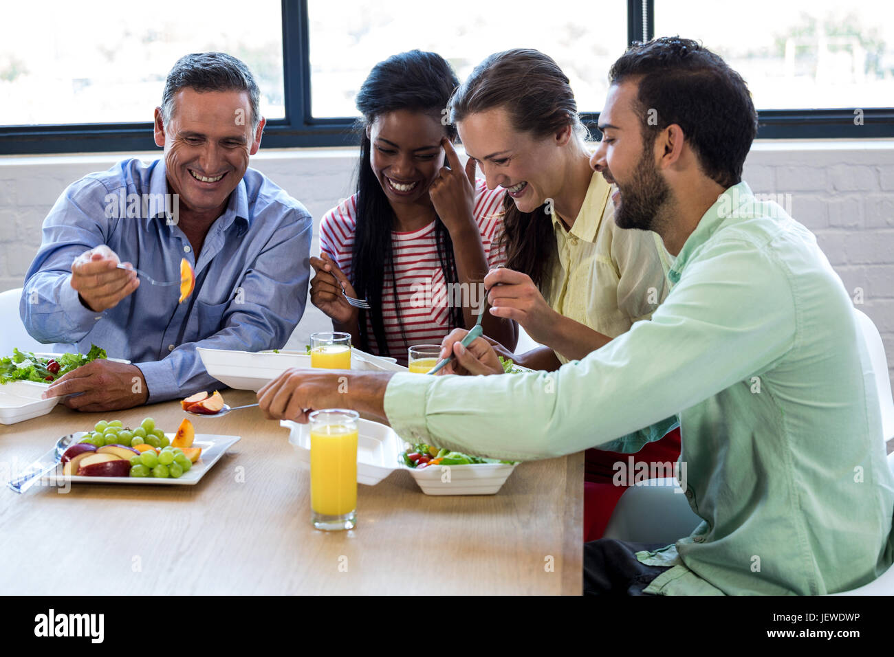 Colleagues having breakfast in office Stock Photo - Alamy