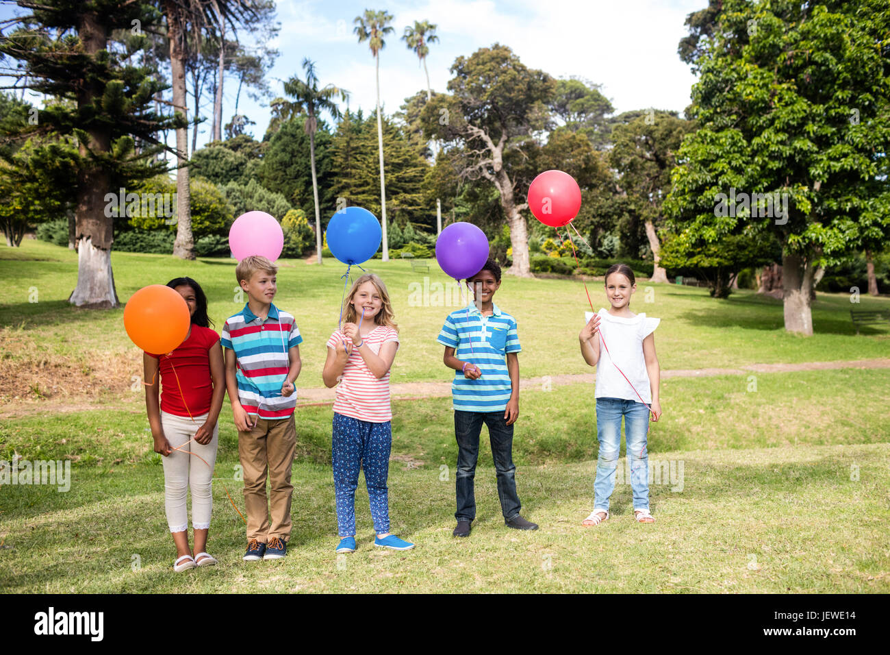 Children standing with balloons in the park Stock Photo - Alamy