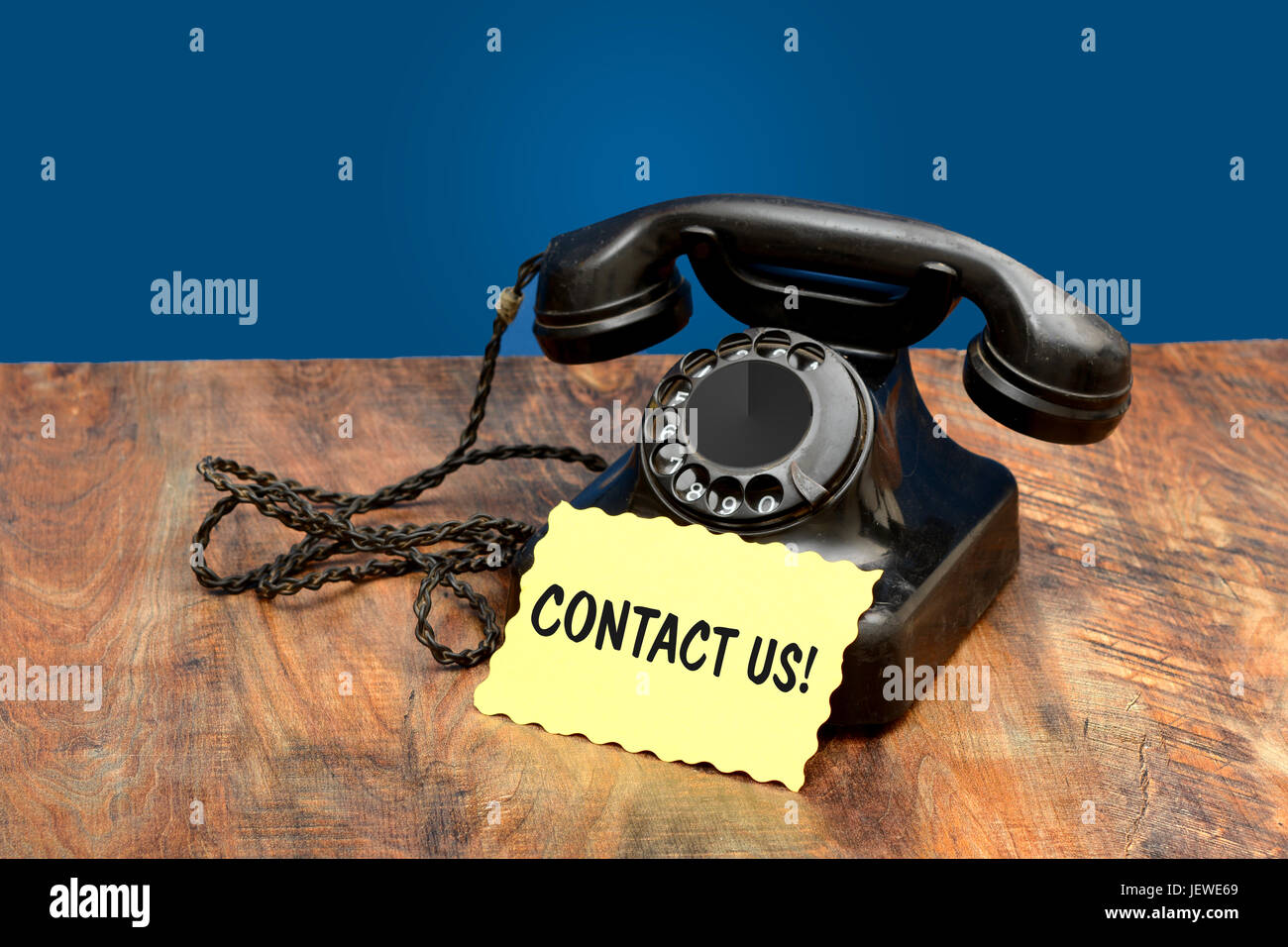 Vintage Phone on Wooden Table with Contact Us Card Stock Photo - Alamy