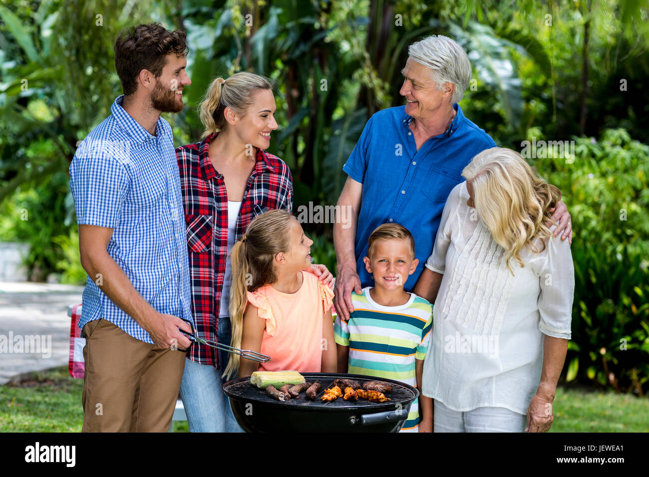 Family grilling food in barbeque at yard Stock Photo - Alamy