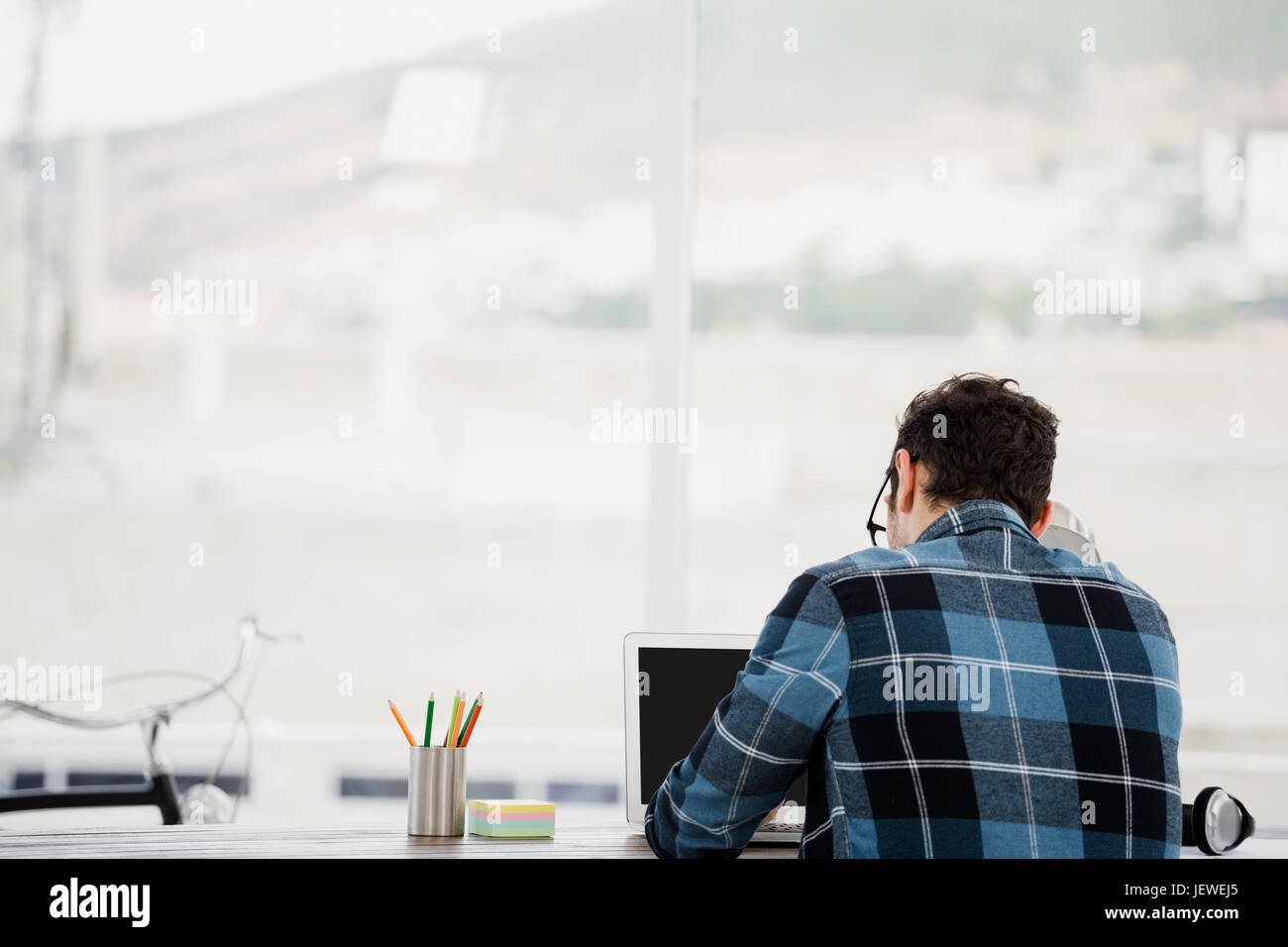 Young man working at his desk Stock Photo - Alamy