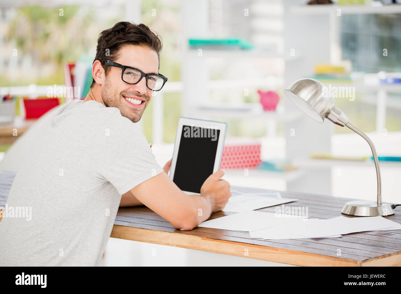 Young man using digital at his desk Stock Photo - Alamy