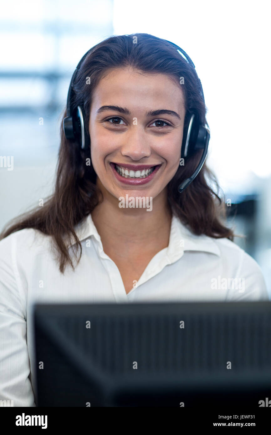 Young woman working on computer with headset Stock Photo - Alamy