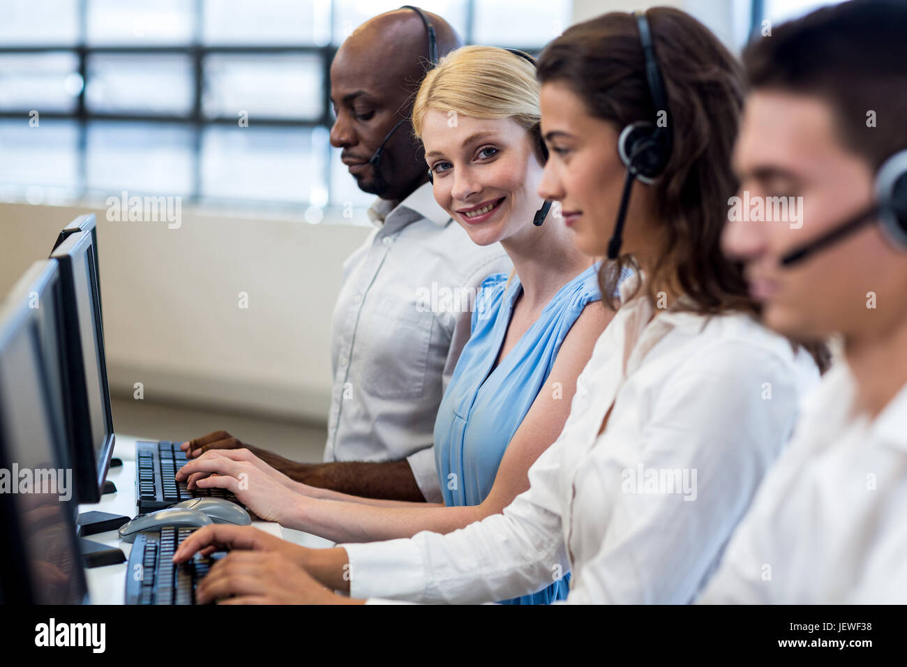 Team working on computer with headset Stock Photo - Alamy