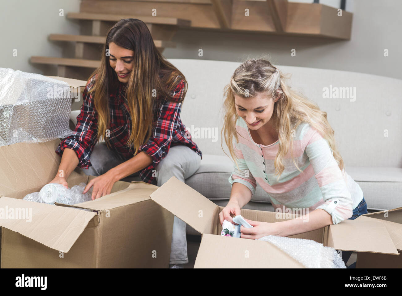Friends unpacking carton boxes Stock Photo - Alamy