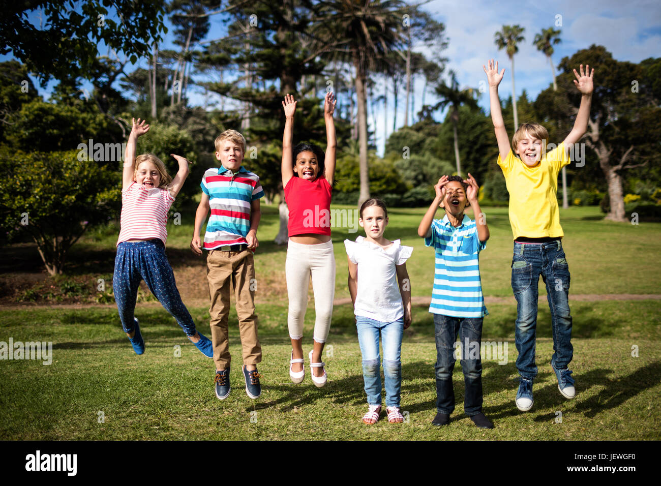 Happy children jumping in the park Stock Photo - Alamy