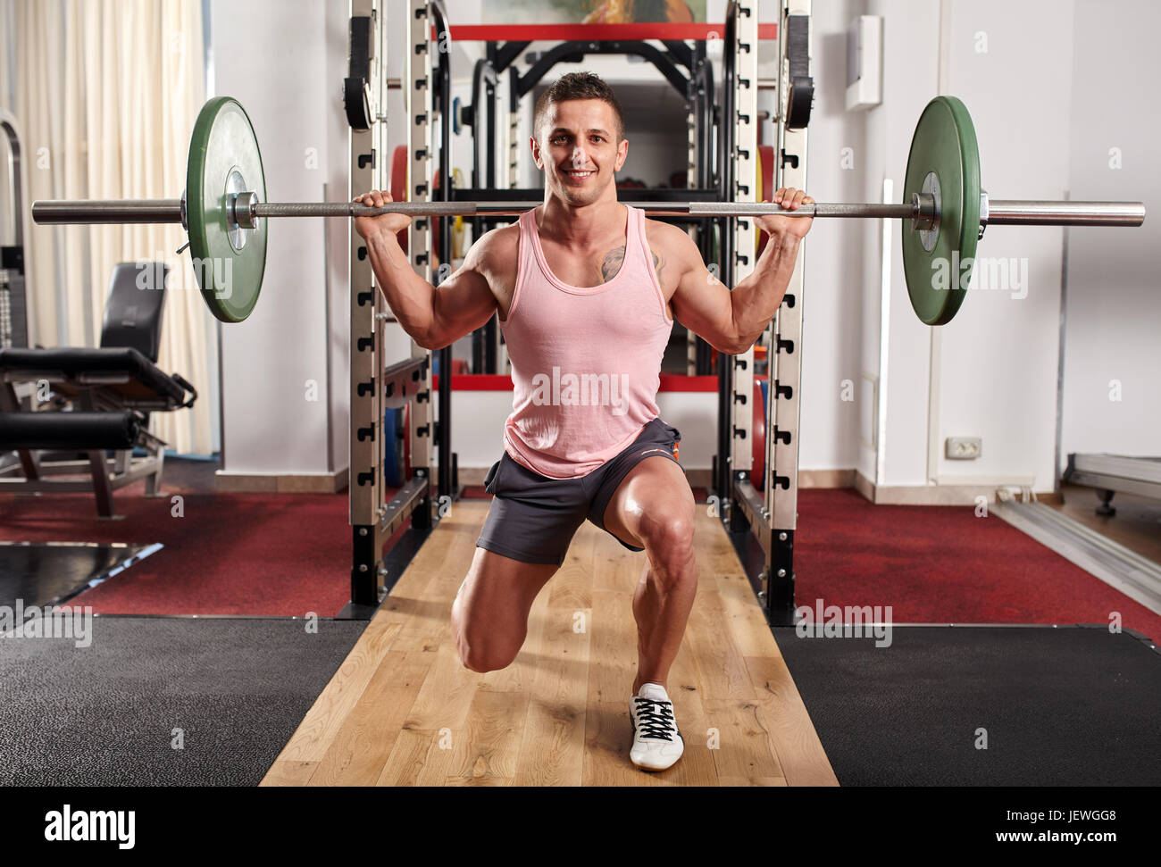 Man doing lunges with heavy barbell in the gym Stock Photo - Alamy